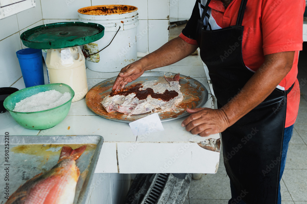 hands of Mexican man cooking grilled fish traditional from Acapulco ...