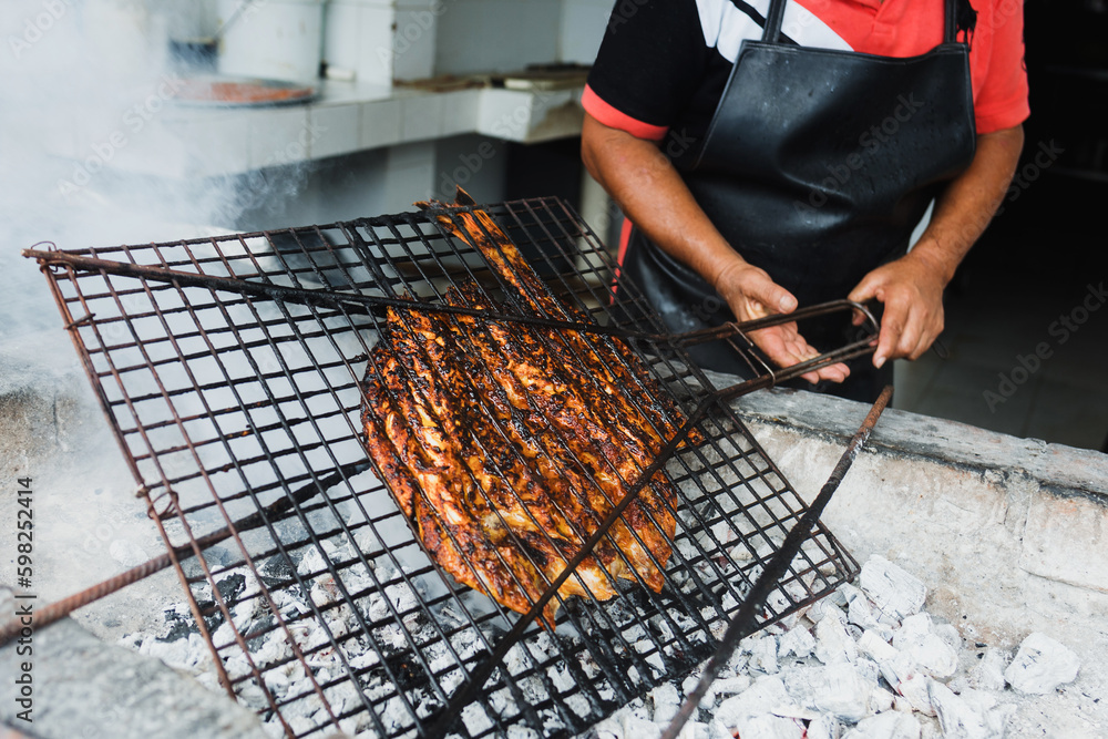 hands of Mexican man cooking grilled fish traditional from Acapulco ...