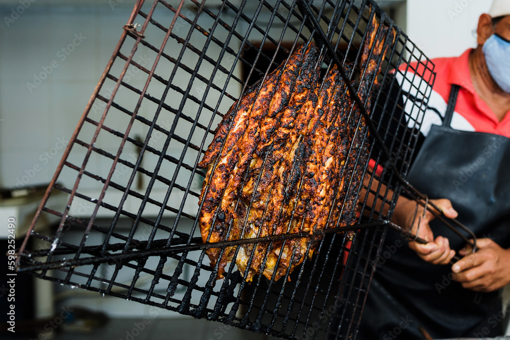 hands of Mexican man cooking grilled fish traditional from Acapulco ...