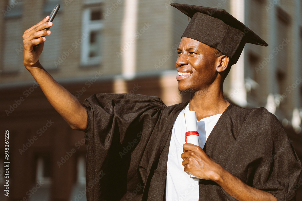 Smiling african american graduate from university taking photo with ...