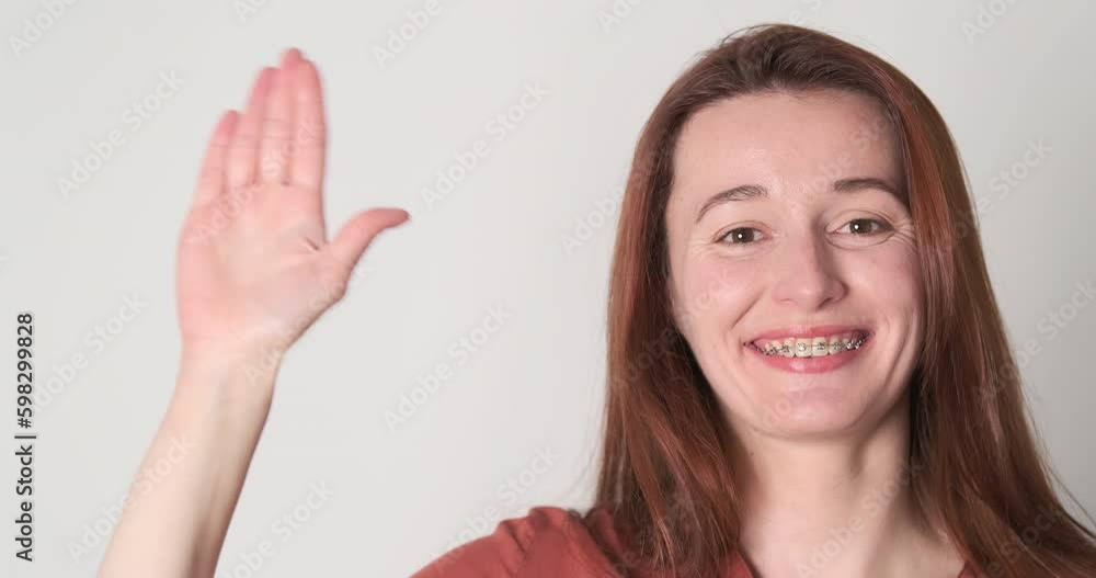 Vidéo Stock Smile and wave. Young woman waving hand at camera. Female ...