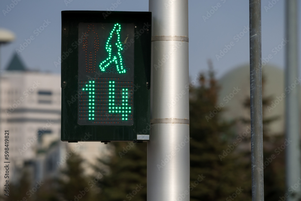 Black traffic light located within the city limits shows a green ...