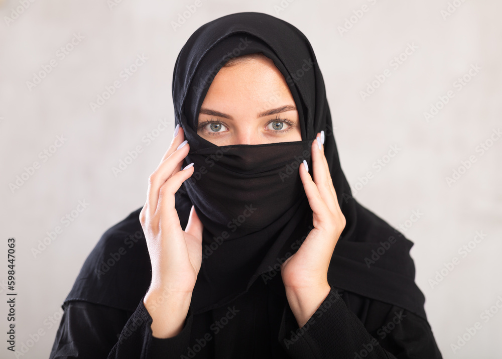 young light-skinned Muslim woman with kind eyes and face covered with ...