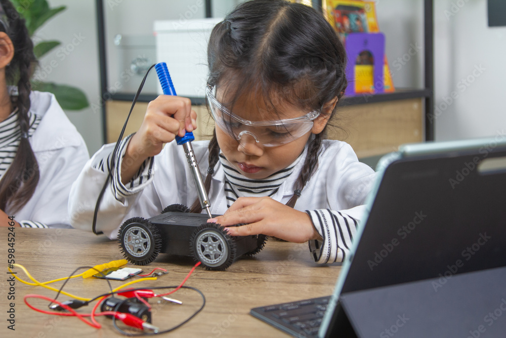 School student making robotic cars. Girl at robotics school makes robot ...