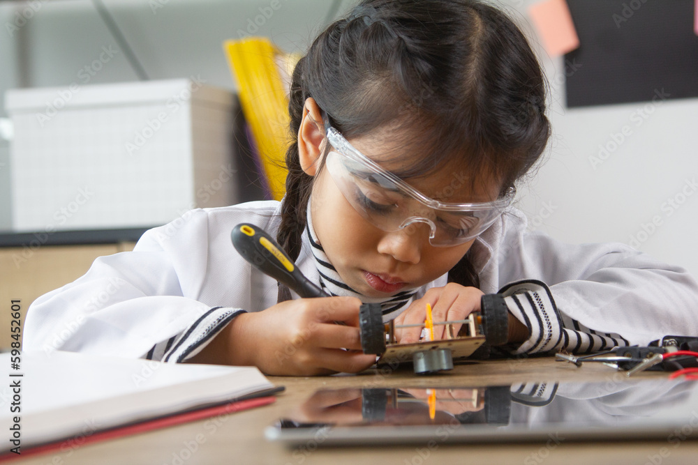 School student making robotic cars. Girl at robotics school makes robot ...