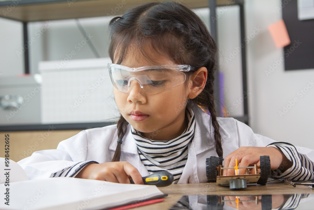 School student making robotic cars. Girl at robotics school makes robot ...