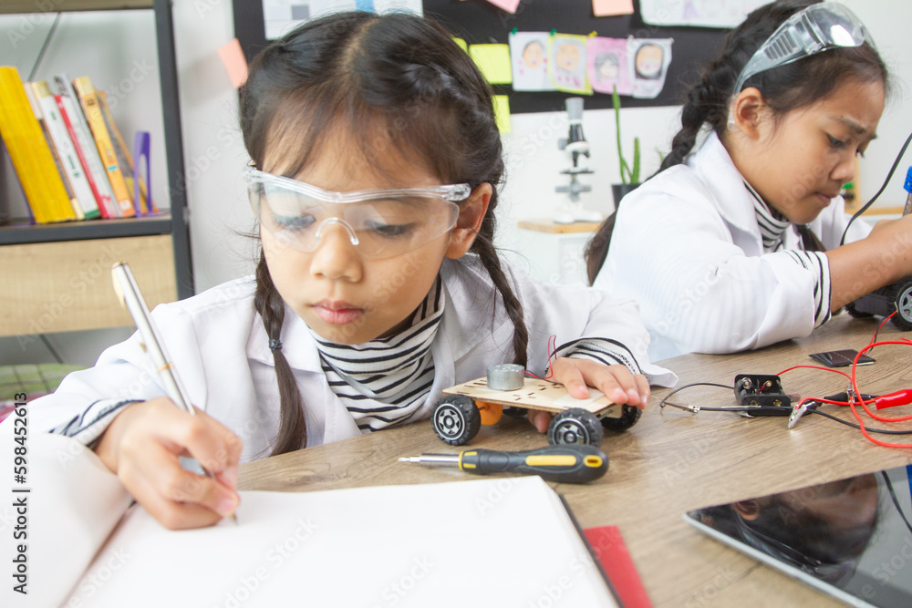 School student making robotic cars. Girl at robotics school makes robot ...
