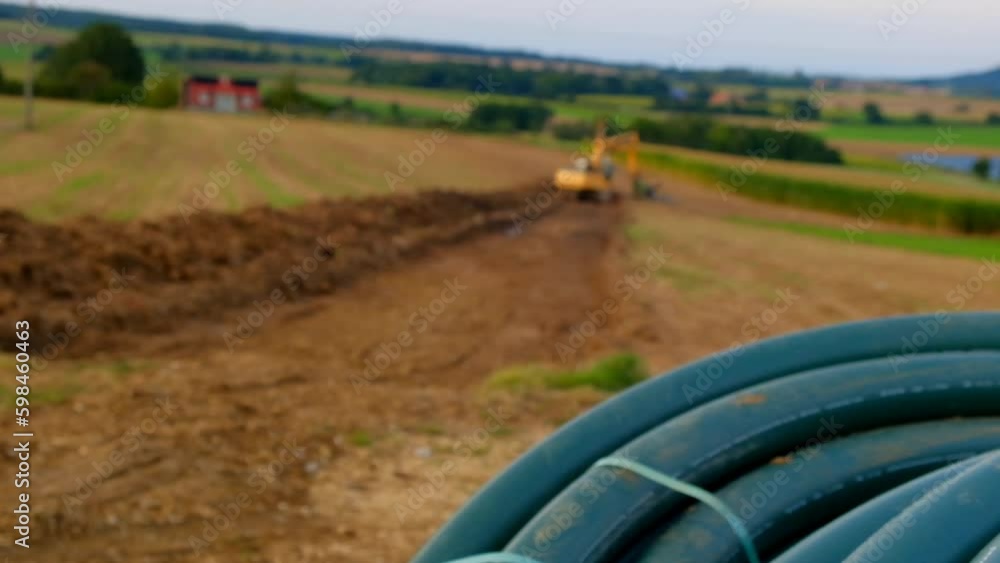 Plumbing installation.Pipe laying.Water pipes and yellow excavator in ...
