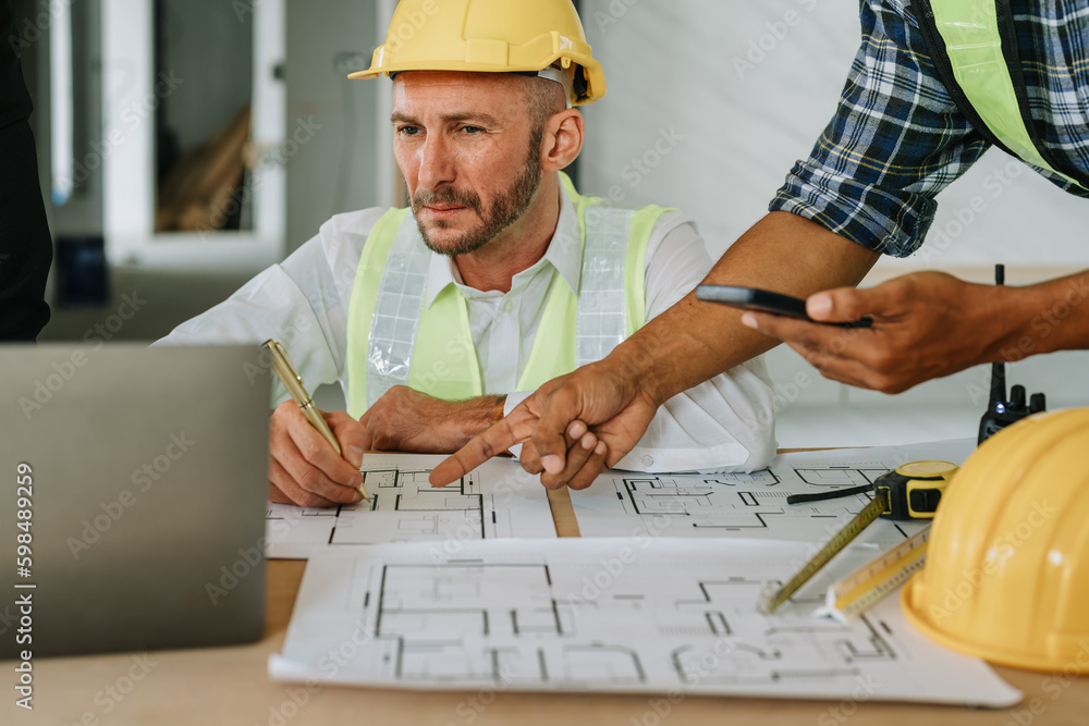 multi ethnic engineer brainstorming and measuring for cost estimating ...