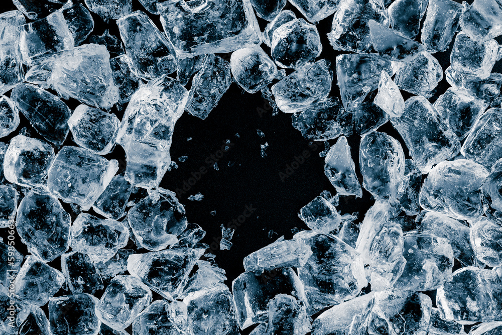 Ice cubes and crushed ice pieces on black background with copy space ...