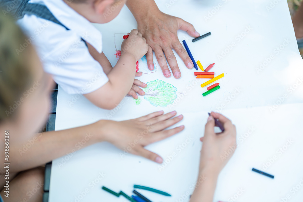 Family activity drawing son using crayons to draw father's hand Stock ...
