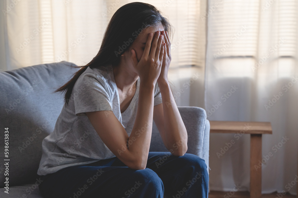 Asian woman covering her face feeling sorrow and depressed sit in the ...