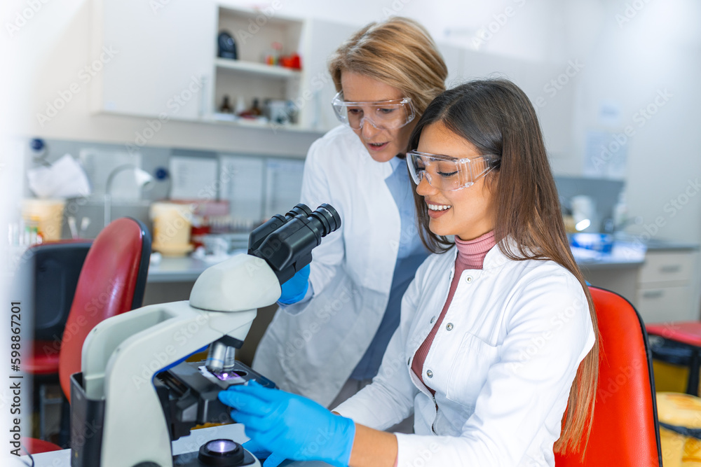 Shot of a Beautiful Female Scientist Looking into the Microscope. Woman ...
