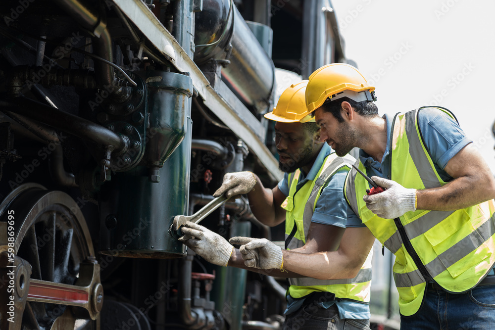 Two male engineer maintenance locomotive engine, wearing safety uniform ...