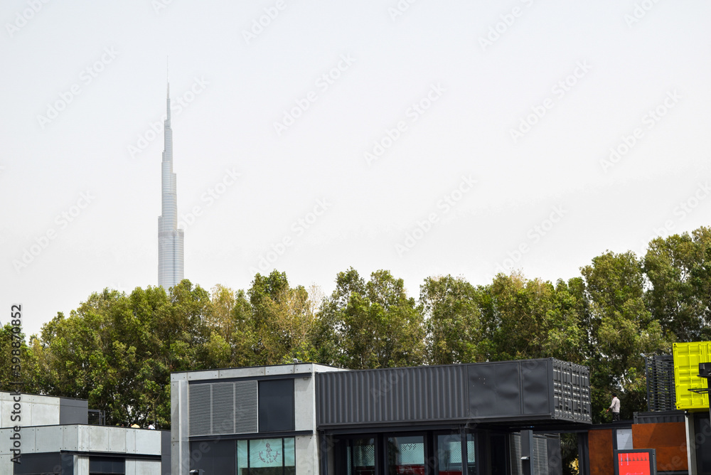 Daytime view of the iconic skyscraper Burj Khalifa over trees and ...