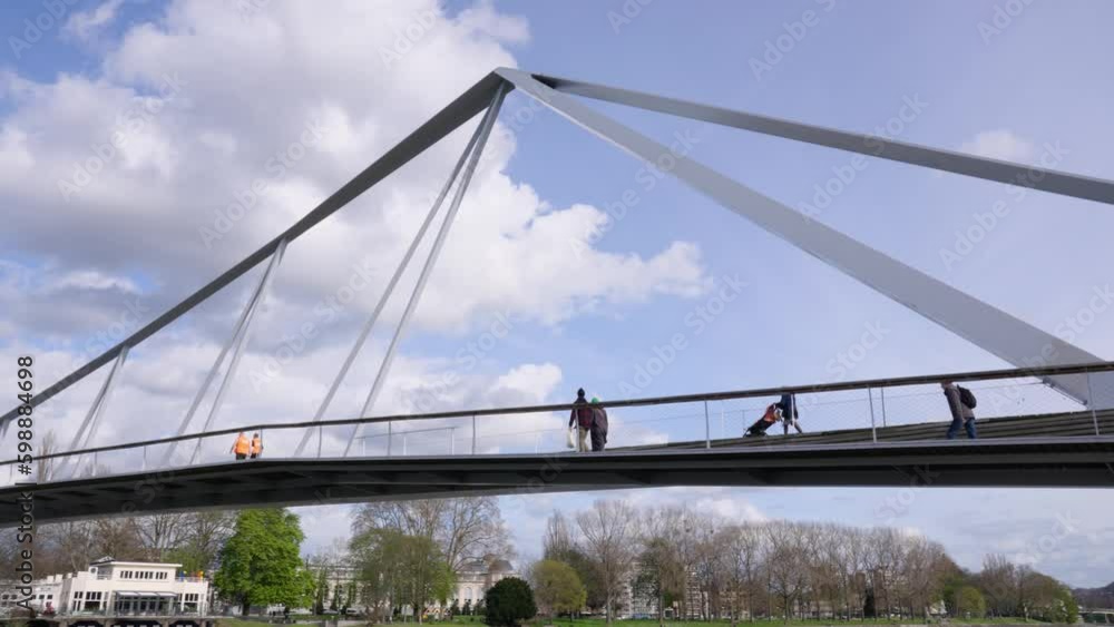 People walking on the Passerelle La Belle Liégeoise. Modern pedestrian ...