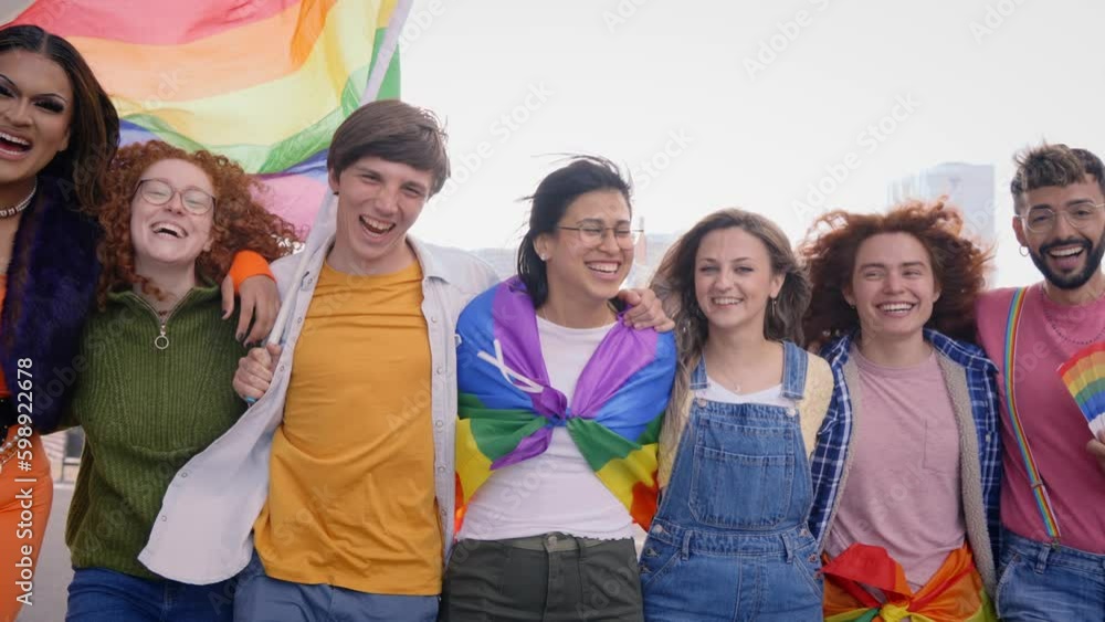 Group of young cheerful friends strolling together on day of gay pride ...