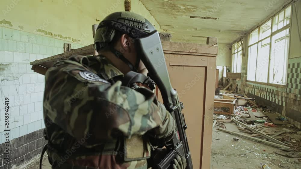 An armed special forces soldier runs into the room and takes shelter ...