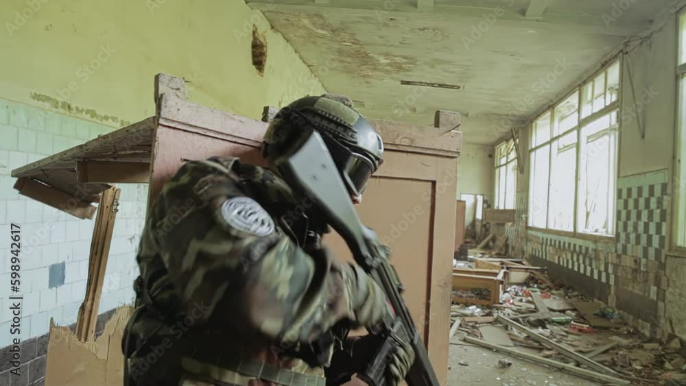 A special forces soldier hides behind a closet in the process of ...