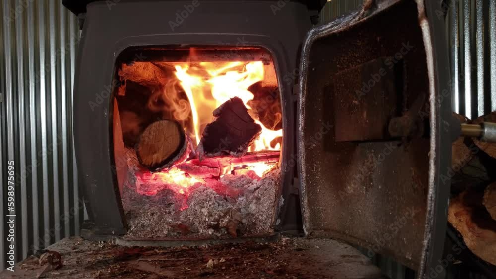 Burning wood inside of cast iron log wood stove while leaving door open ...
