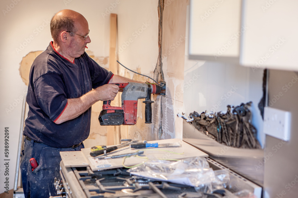 Kitchen Fitters: Electrical Installation.An electrician drilling cable ...