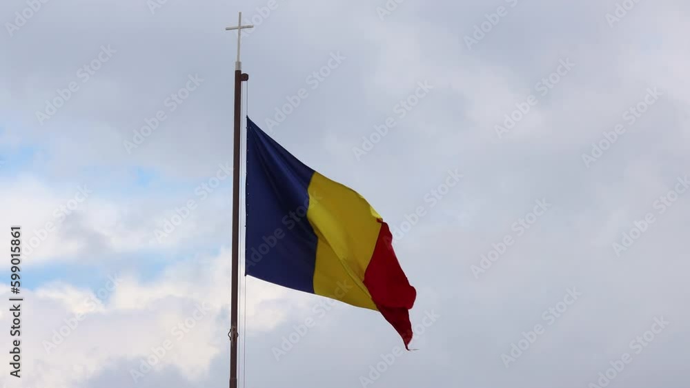 Romanian flag waving on clear blue sky background with clouds. The ...