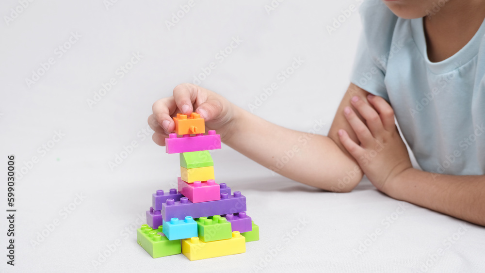 Children play with colorful plastic lego bricks while sitting on the ...