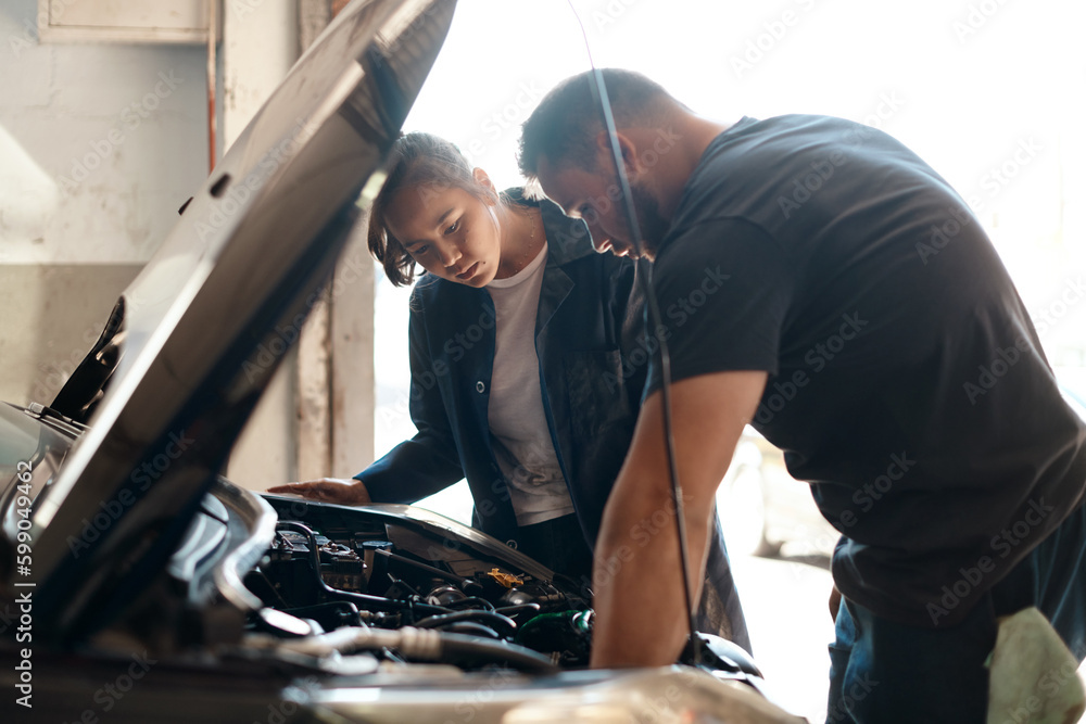 Trying to identify the source of the problem. two mechanics working ...