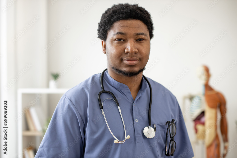Portrait of attractive multicultural man in blue scrubs and stethoscope ...