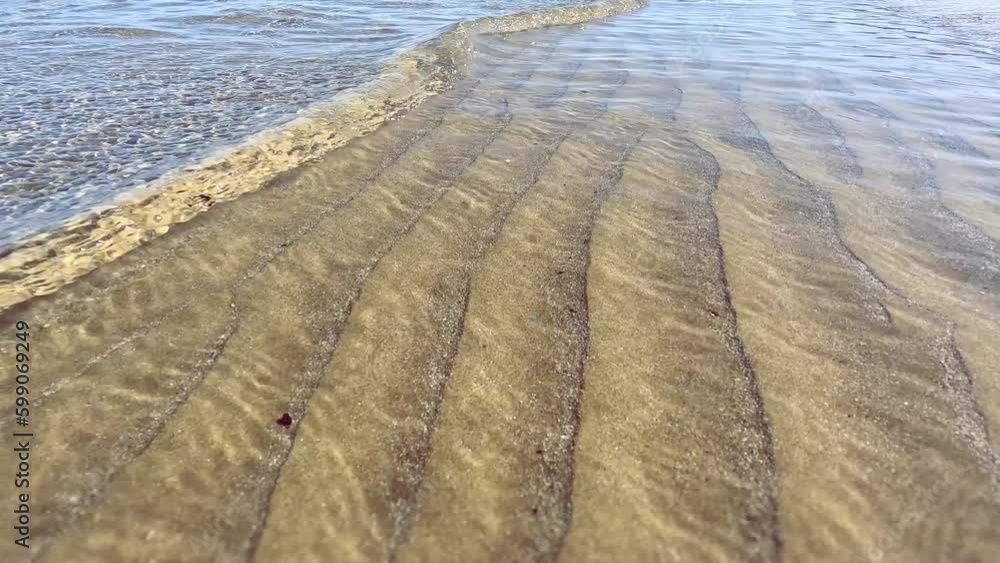 Sea surface closeup slow motion. Rays of sun shining on the sea. Small ...