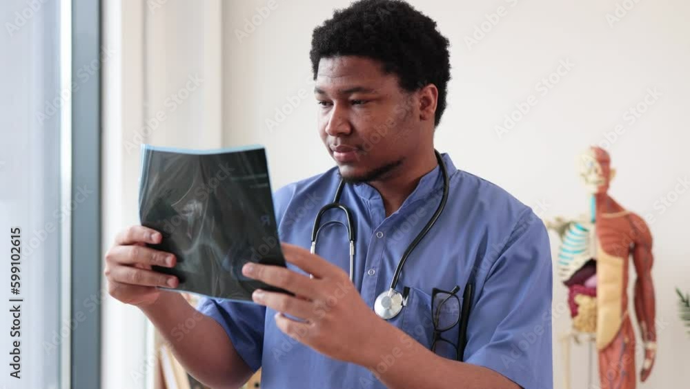 Mindful multiethnic male in scrubs wearing stethoscope and folded ...