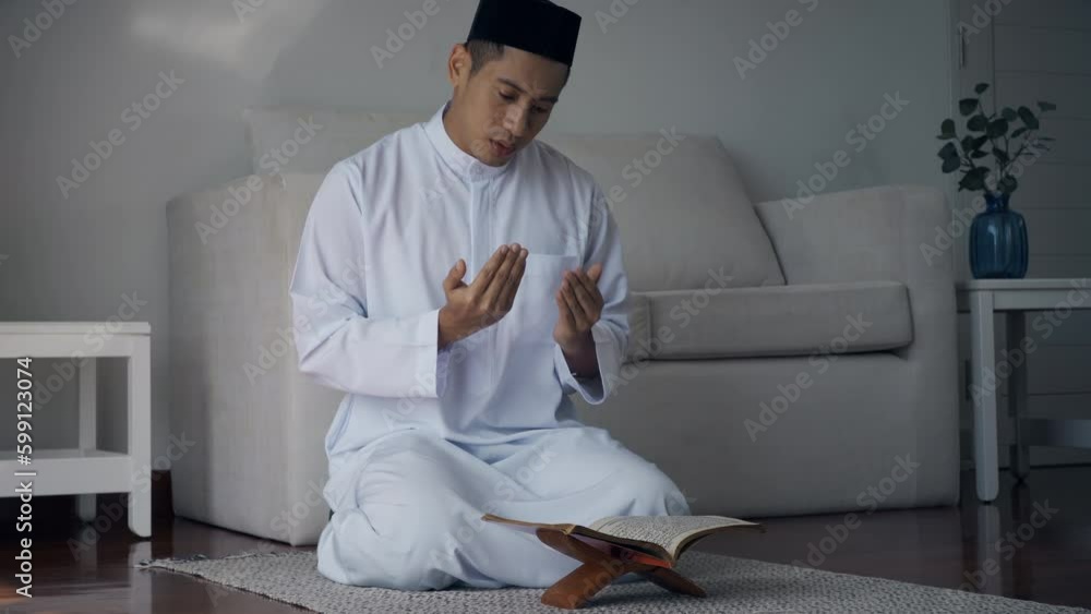 Asian Muslim man reciting surah al-Fatiha passage of the Qur'an, in a ...
