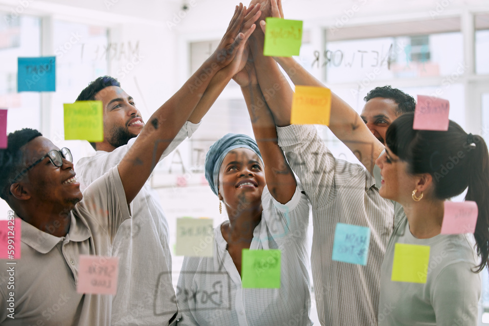 Building up our team spirit. a group of young businesspeople giving ...