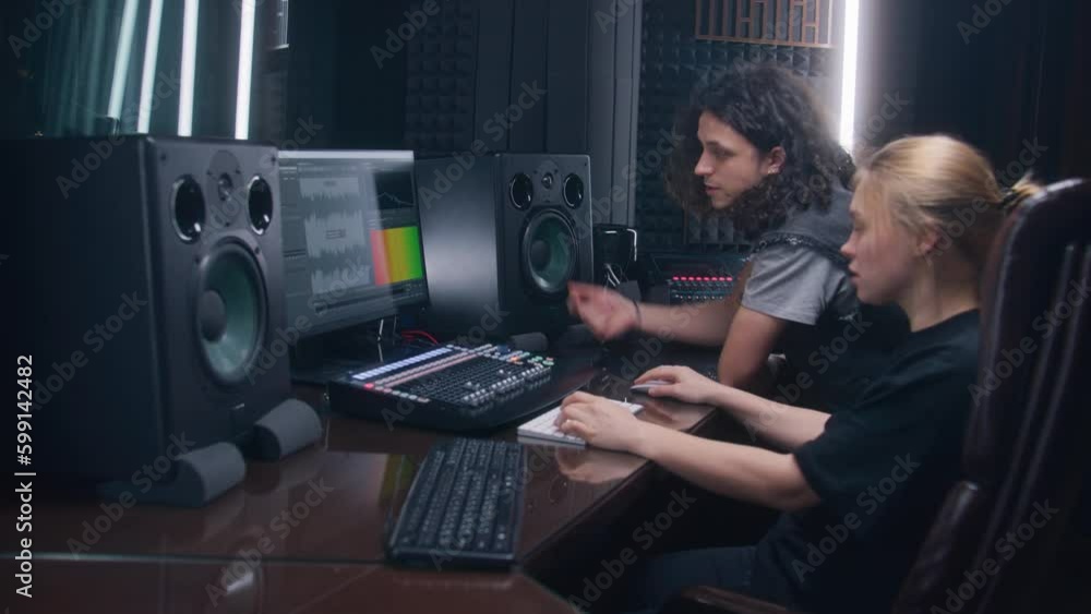 Female audio engineer and singer create song in music recording room ...