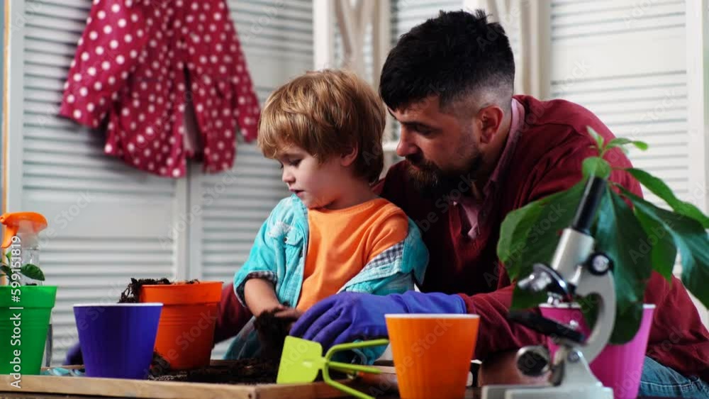 Father ans son child growing plant in pot. Happy loving family at home ...