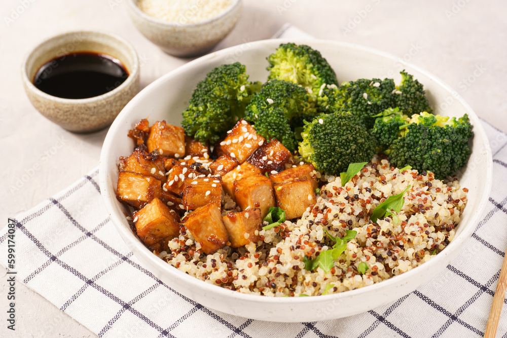 One quinoa bowl with steamed broccoli and smoked tofu cubes in teriyaki ...