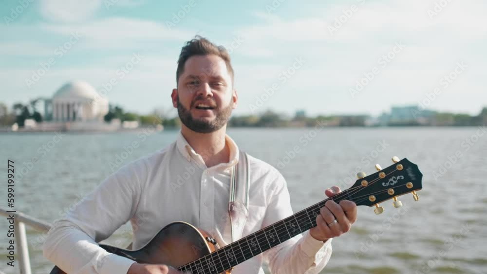 Adult artist singing and playing his guitar across the Thomas Jefferson ...