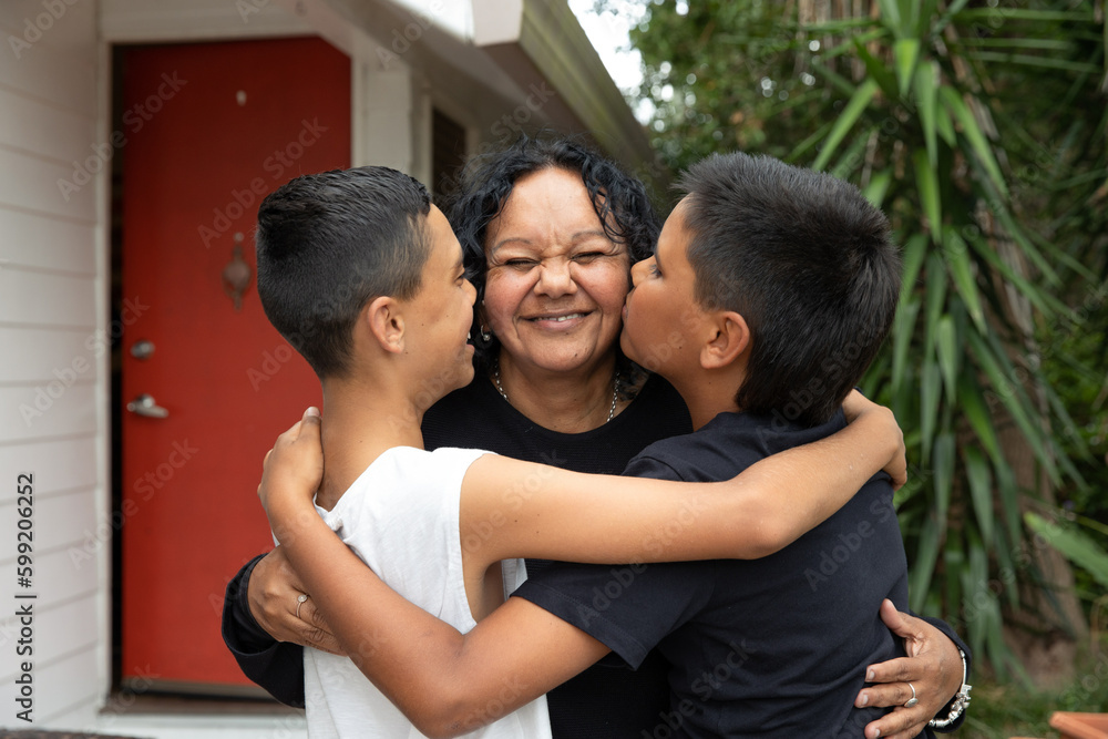 Aboriginal family hugging and kissing in backyard Stock Photo | Adobe Stock