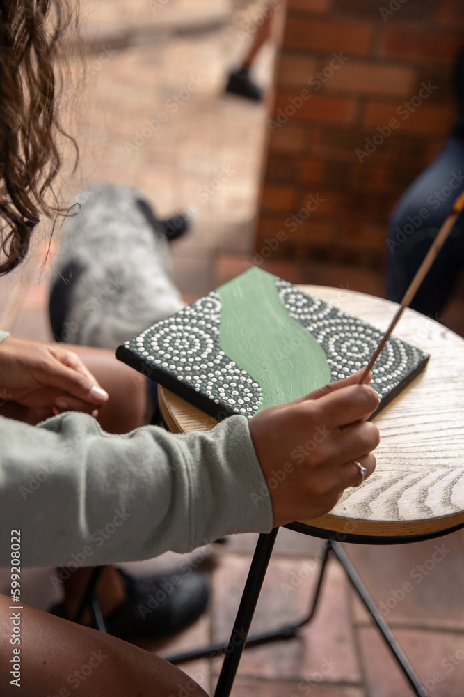 Aboriginal girl dot painting on a stool Stock Photo | Adobe Stock