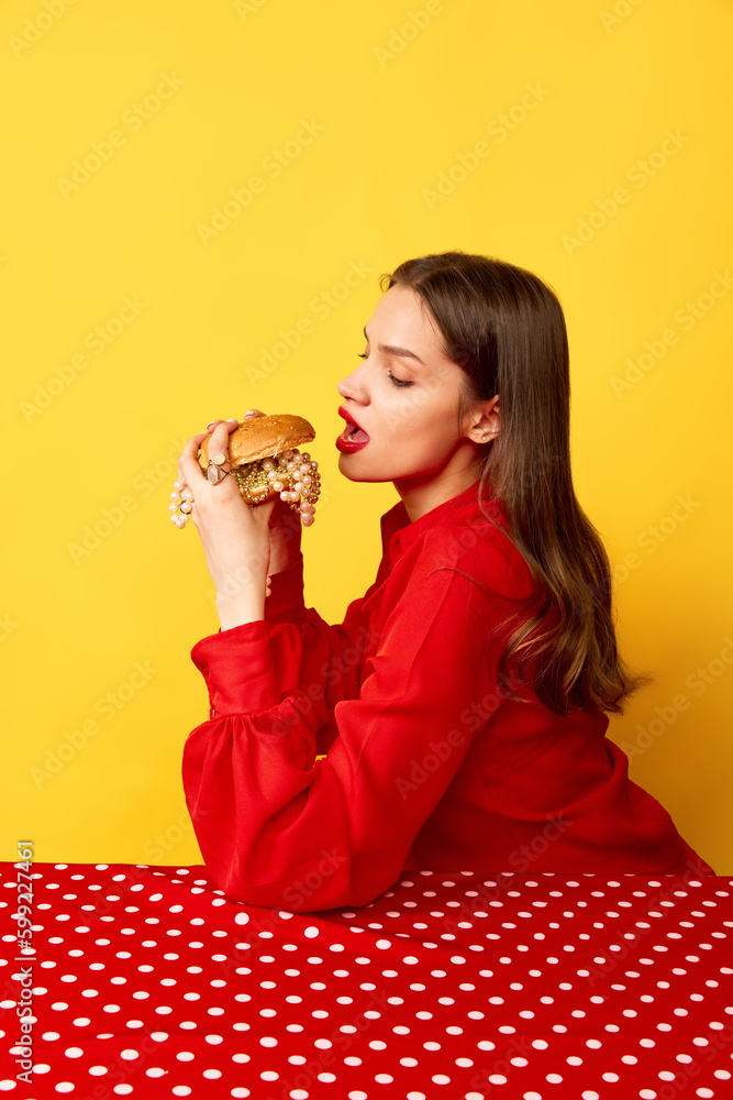 Portrait of charming hungry woman eating big burger with desire face ...