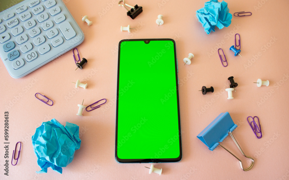 Top view, Smart phone on pink background with green screen and office ...