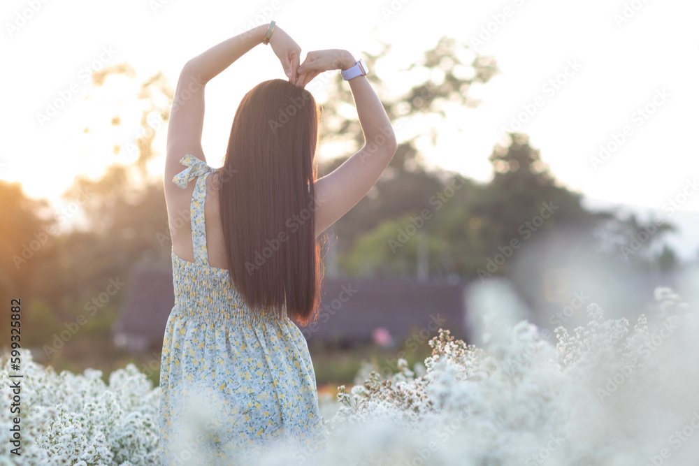 woman holds her hand above her head to form heart symbol that ...