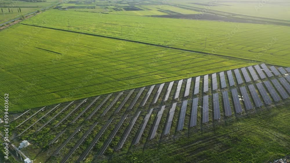 An aerial view of solar panels set amidst a desert landscape. The ...