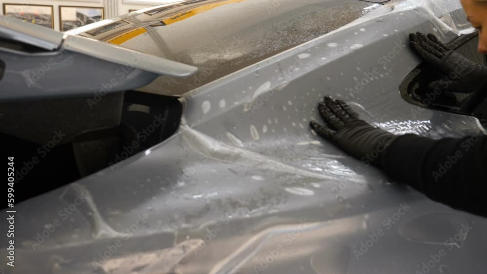 Close up to PPF installation process on a front headlight and hood. PPF ...