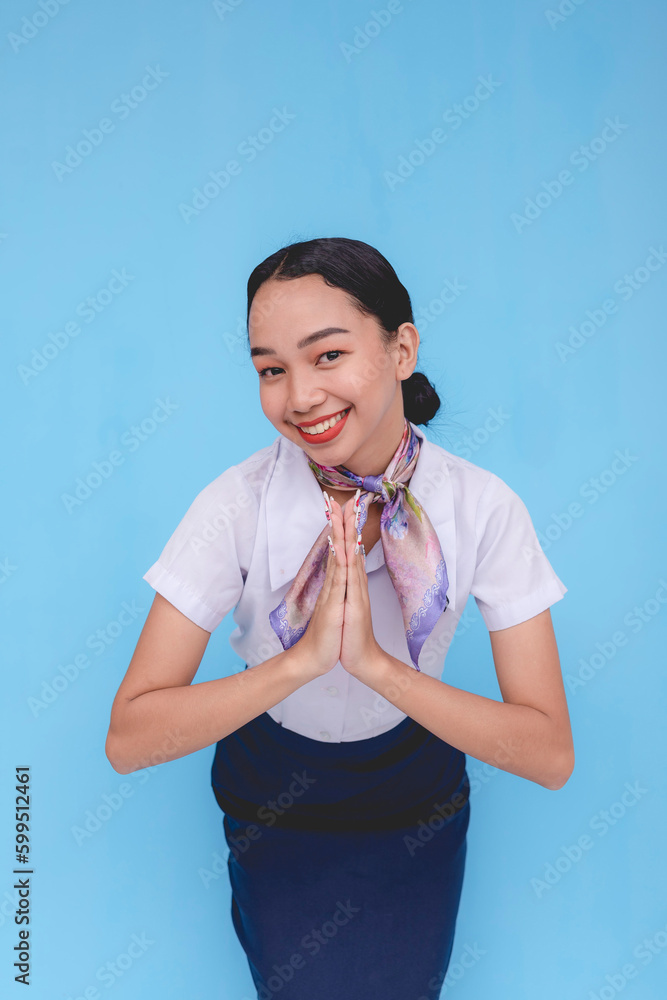 A flight attendant doing the Namaste pose. A stewardess showing respect ...