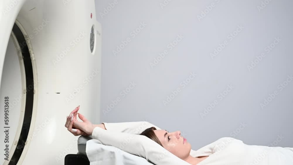 Young woman is undergoing a CT scan procedure. Pretty female in a ...