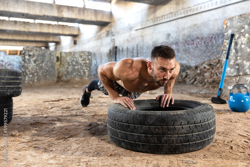 Strong, muscular man doing pushups inside an abandoned-closed factory ...