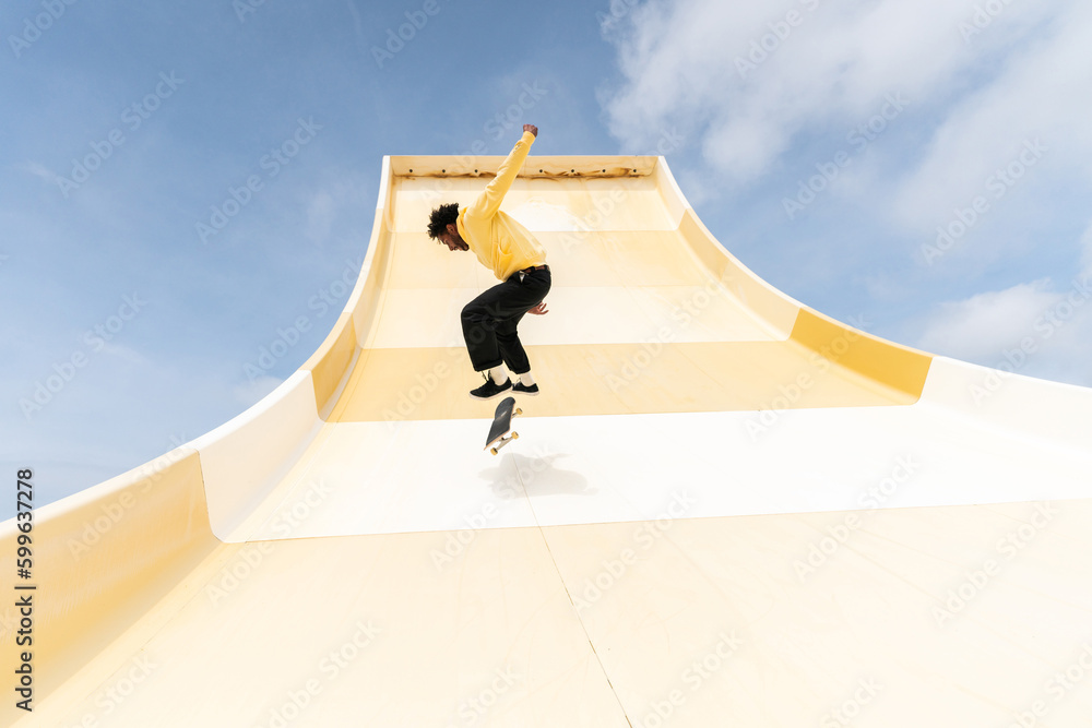 Stylish ethnic man running on skate ramp Stock Photo | Adobe Stock