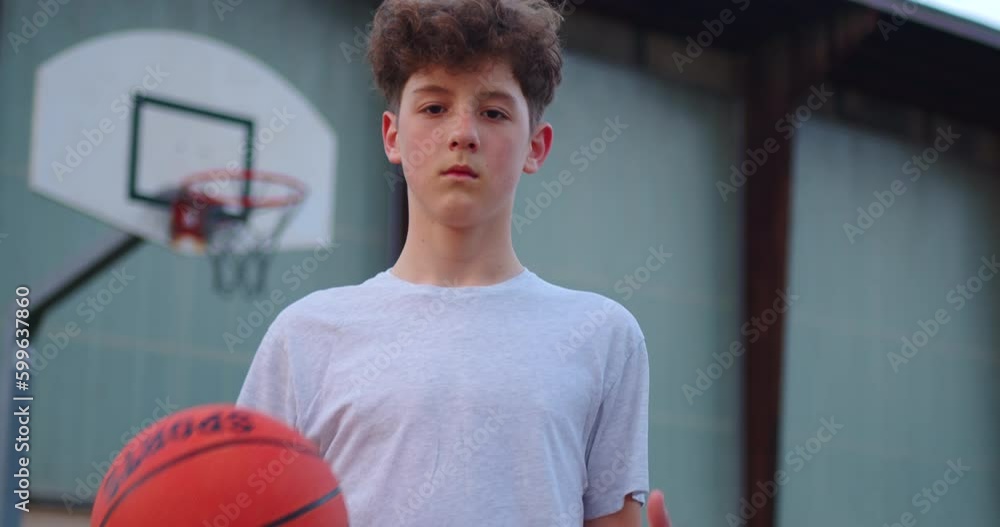 Video of a boy standing on a basketball court and holding a basketball ...