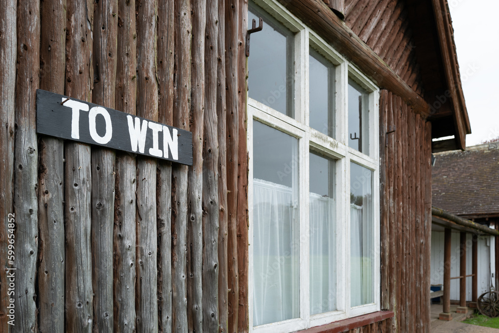 Shallow focus of a To Win sign seen attached to the wall of a timber ...